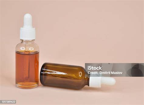 분홍색 배경에 분리 된 파이펫이있는 화장품 병 한 병은 액체 두 번째는 비어 있습니다 0명에 대한 스톡 사진 및 기타 이미지