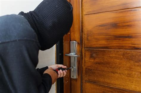 Premium Photo Thief Burglar Opening Wooden Door With Lock Picker