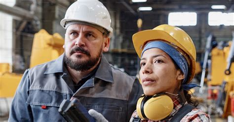 거대한 산업 기계의 높이를 조절하면서 원격 제어의 버튼을 누르는 작업귀에 젊은 여성 기술자 사진 Unsplash의 종업원 이미지