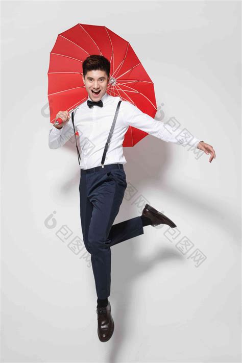 青年男人拿着心形红雨伞跳跃拿着高端摄影图片 包图网企业站