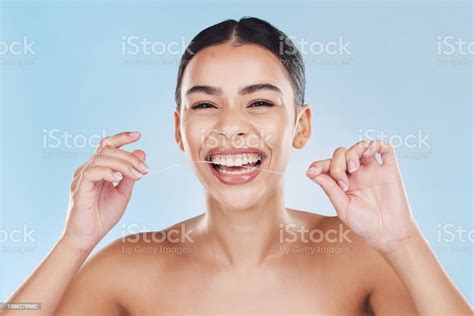 푸른 배경에 스튜디오에서 고립 된 치실을 사용하는 아름다운 젊은 혼합 경주 여성 구강 및 치과 위생과 잇몸 건강을 위해 치아를 치실하는 매력적인 여성과 큰 미소 20 24