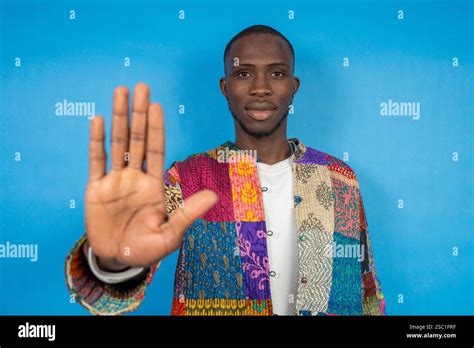Confident Young Man Making Stop Gesture With Hand Expressing Refusal