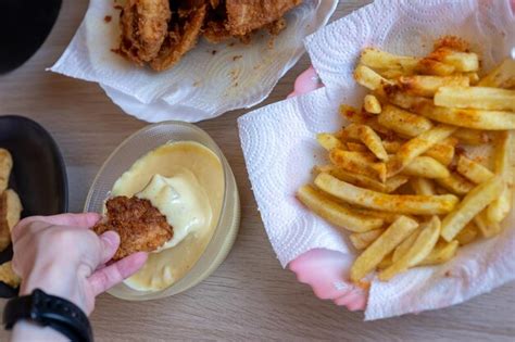 Premium Photo Human Hand Holding Chicken Fillet With French Fries On