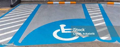 장애인 또는 휠체어 주차 표지판은 주차장에 장애인을위한 예약 주차를 나타냅니다 쇼핑 센터 주차 공간에 밝은 파란색으로 그려진 국제 장애인 기호 0명에 대한 스톡 사진 및