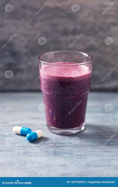 Glass Of Protein Shake With Milk And Blueberries And Creatine Capsules