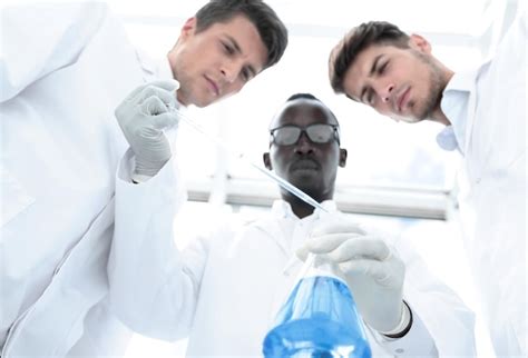 Premium Photo Group Of Scientists Examines The Liquid In The Flask