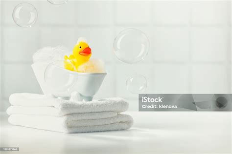 욕실 조리대에 미니어처 버블 욕조 노란색 고무 오리와 흰색 수건 어린이 목욕 액세서리 베이비 케어 오리 물새에 대한 스톡 사진