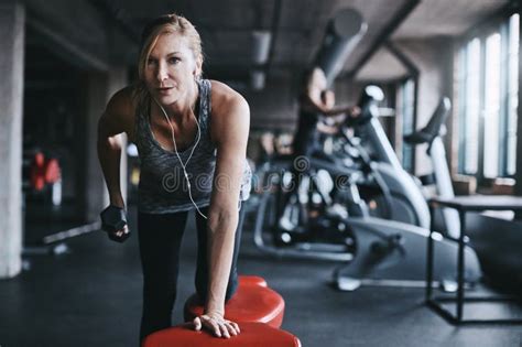 Toning Her Arms An Attractive Young Woman Listening To Music While