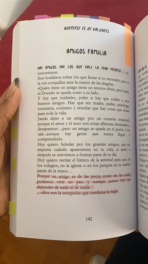 A Person Is Holding An Open Book In Their Hand With Spanish Writing On