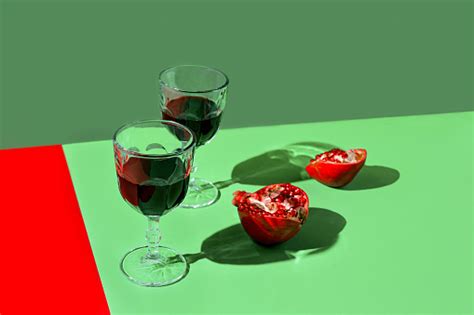 레드 와인 이나 주스와 석류로 만든 창조적 인 구성은 햇빛과 그림자녹색 백고운에 여름 다과 컨셉 최소한의 스타일 0명에 대한