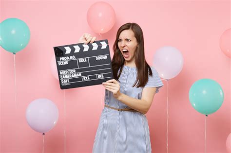 블루 드레스 화려한 공기 Baloons와 분홍색 배경에 Clapperboard 만드는 고전적인 흑인 영화를 들고 비명에 화가 염증된 여자의 초상화 생일 휴가 파티 사람들이