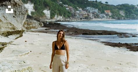 Uma Mulher Em Pé Em Cima De Uma Praia De Areia Foto Imagem Grátis