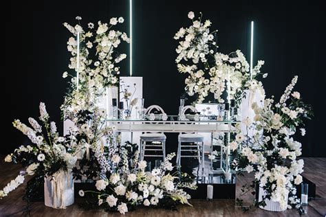 결혼식 파티에서 연회장에 있는 신혼부부들 아치로 장식된 꽃과 녹지가 있는 축제 테이블 홀 레스토랑의 검은 촛불 럭셔리한 실버 장식 테이블 세팅 리셉션 0명에 대한 스톡 사진