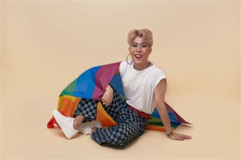 누드 색상 배경 위에 절연 어깨에 무지개 깃발을 가진 청소년 아시아 트랜스 젠더 Lgbt 무료 사진
