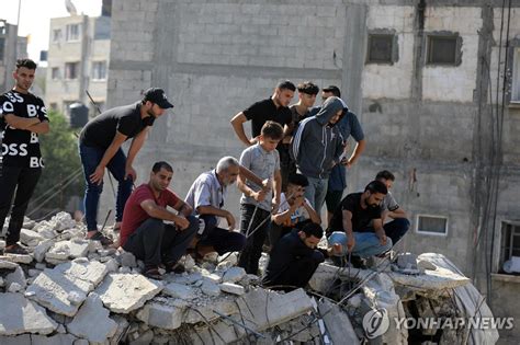 잔해 더미 위에 앉아있는 가자지구 주민들 연합뉴스