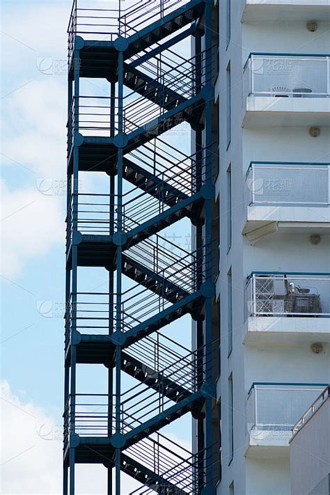 以天空为背景的住宅楼墙上的金属防火梯