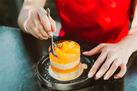 오렌지와 크림을 겹겹이 쌓은 맛있는 디저트로 접시에 담겨 제공됩니다 사람은 포크와 함께 이 달콤한 간식을 즐기며 생생한 색상과 질감을 강조합니다 다중 색상에 대한 스톡 사진