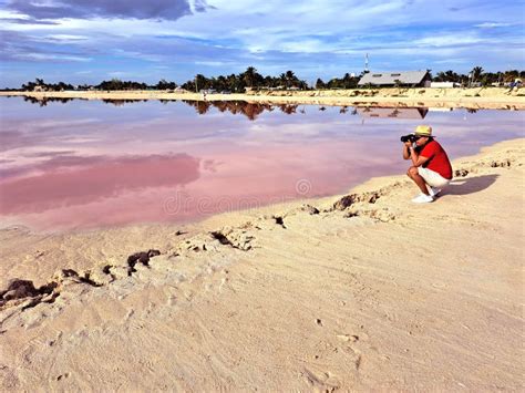 Photographer Man Takes Pictures Next To The Pink Colored Lagoon With A