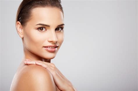 Increíble chica con cabello castaño piel limpia y fresca y hombros