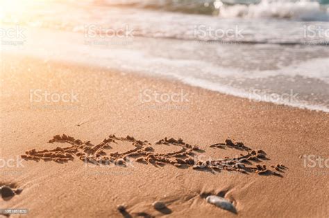 2022 년 모래 해변 새해 복 많이 받으세요 2022 아름다운 일몰 황금 빛에 황금 모래에 기록 된 숫자 손 바다의 물결은