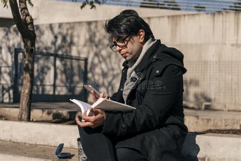 Hombre Sentado En Un Banco De Hormign En Un Parque Pblico Leyendo Un