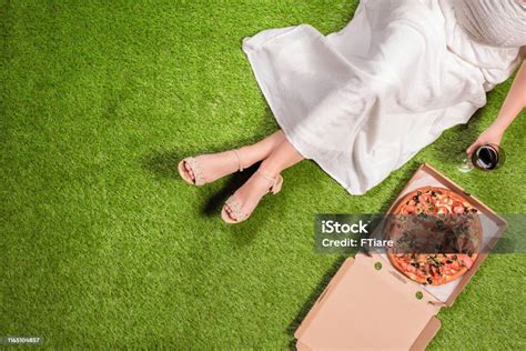 잔디에 정원에서 피크닉 상자에 피자와 와인 한 잔흰색 여름 드레스에 젊은 여자에 공중 보기 건강에 좋지 않은 음식에 대한 스톡
