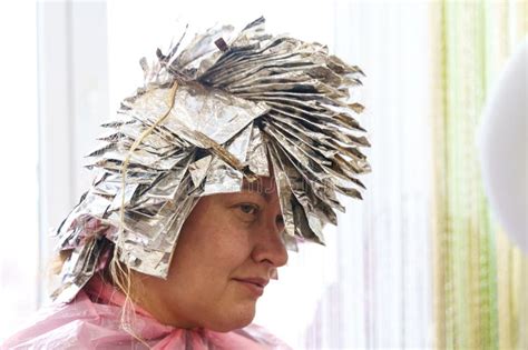 A Woman With Colorful Hair Undergoes A Foiling Treatment At A Salon