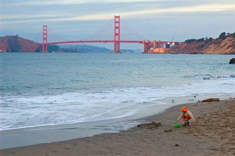 Menina Que Joga Na Praia Na Ponte Do Por Do Sol E De Porta Dourada Foto