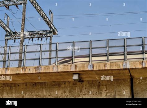 low angle view of speeding train crossing concrete rail bridge under
