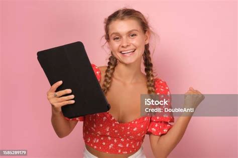 젊은 행복한 백인 여자는 전자 태블릿을 들고 승리의 몸짓을 한다 20 29세에 대한 스톡 사진 및 기타 이미지 20 29세 공란 과거 Istock