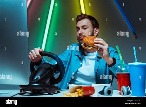 Focus Sélectif De Handsome Sportsman Cyber Burger Manger Et Jouer Le