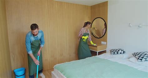 균일 한 세탁 층의 전문 청소기와 호텔 방이나 아파트 침실의 가구에서 먼지를 닦아 청소 서비스 개념입니다 가사 집안일에 대한