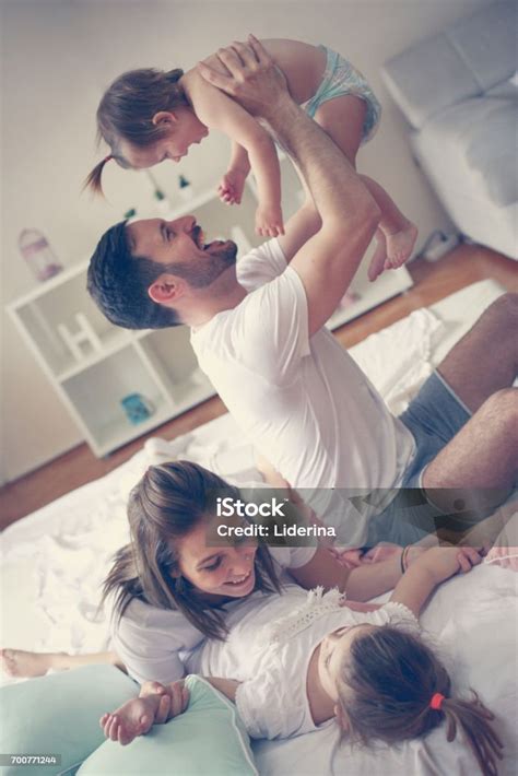 가족 집에서 자유 시간을 보내고입니다 침대에 그들의 딸과 재미 명랑 한 가족 3 명에 대한 스톡 사진 및 기타 이미지 3 명