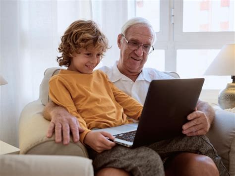 Premium Photo Cheerful Grandson With Grandfather Browsing Netbook