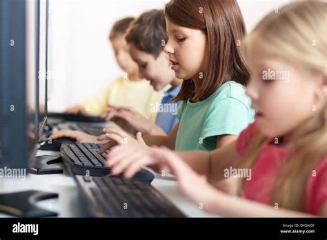 Portrait Of Lovely Schoolgirl Looking At Computer Keyboard While Typing