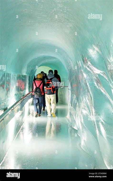 Travelers Walking Through A Tunnel Of Ice Palace At Jungfraujoch