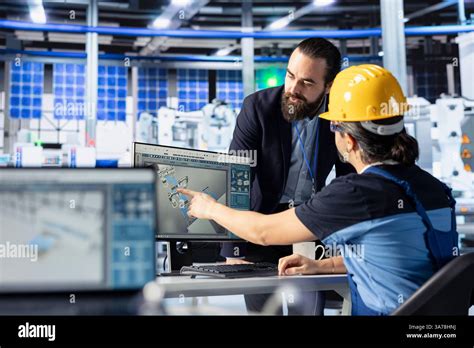Photovoltaics Factory Engineer Pointing To Screen Showing Manager Ways To Optimize Production