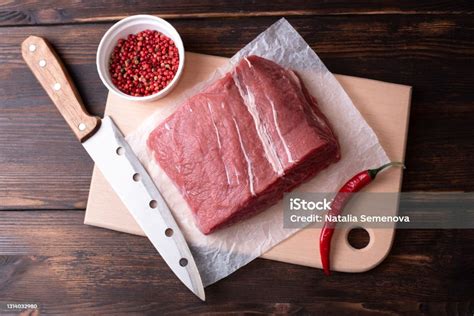 칼과 향신료가 있는 도마에 있는 큰 송아지 고기 조각 어두운 나무 배경에 신선한 필레 소박한 스타일 0명에 대한 스톡 사진 및