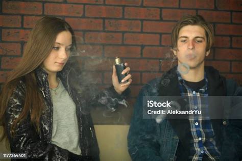 Vape 청소년 선글라스와 젊은 잘 생긴 남자에 젊은 귀여운 소녀는 Vape 바에서 전자 담배를 연기 건강에 해로운 나쁜 습관 십대에 대한 스톡 사진 및 기타 이미지
