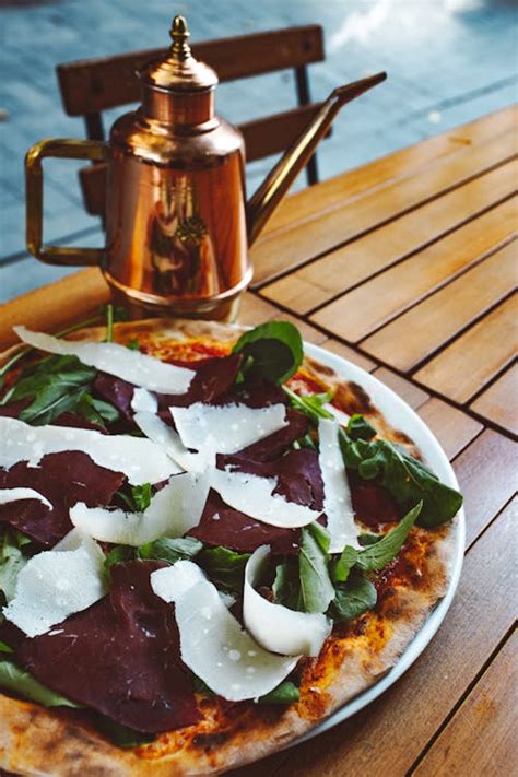 고기 토핑 구리 냄비 구리 주전자 군침이 도는 레스토랑 설정 맛있는 맛있는 식사 먹음직스러운 멋을 아는 목조 테이블 미식가 피자 바삭한 크러스트 바질