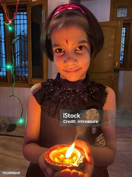 빛의 기름이 가득한 점토 디야를 손바닥에 들고 있는 인도 소녀의 이미지 불이 켜진 심지의 디왈리 오일 램프 어두운 불꽃 디왈리 축제 의 조명 축제 전경에 초점을 맞추고 6
