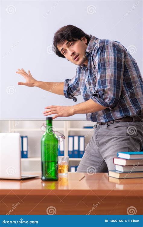 El Profesor De Sexo Masculino Que Bebe En La Sala De Clase Foto De Archivo Imagen De