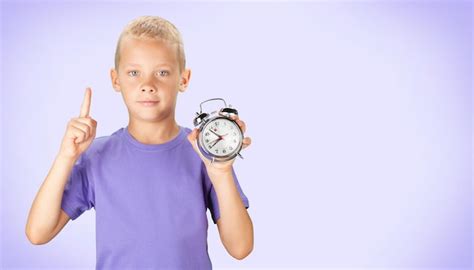 Premium Photo School Boy Showing Alarm Clock