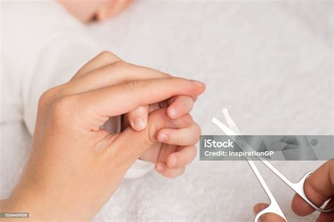 고립 된 흰색 섬유 배경에 신생아의 손가락과 아기 손톱 가위를 들고 어머니의 손의 클로즈업 사진 2명에 대한 스톡 사진 및 기타