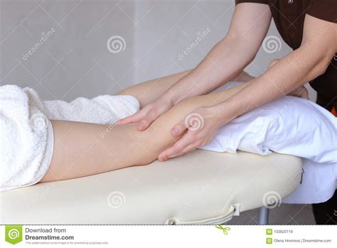 Handsome Male Massage Therapist Performs Procedure For Girl`s Le Stock