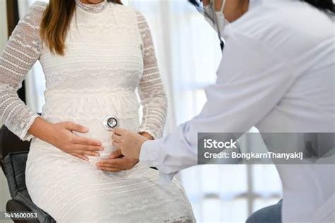 의사가 위장을 확인하는 동안 의자에 앉아 있는 임산부 산전 관리 25 29세에 대한 스톡 사진 및 기타 이미지 25 29세