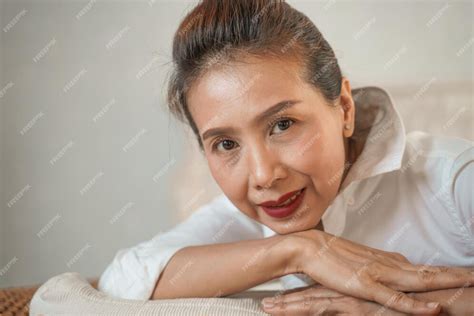 Premium Photo Portrait Of A Smiling Young Woman Lying On Bed
