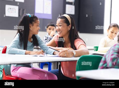 In School Young Biracial Female Teacher Is Talking To A Young Biracial