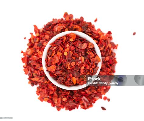 흰색 배경에 고립 된 그릇에 말린 빨간 칠리 플레이크 다진 칠리 카이엔 후추 향신료와 허브 맨 위 보기입니다 가루로 빻은에 대한