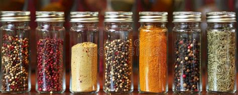 Close Up Of Various Spices In Glass Jars With Metal Lids Each